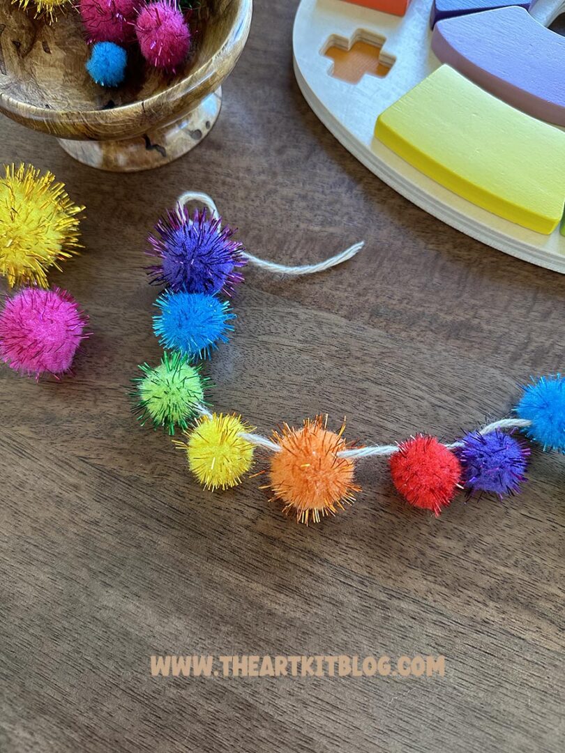 Cute! DIY Rainbow Pom Pom Garland - The Art Kit